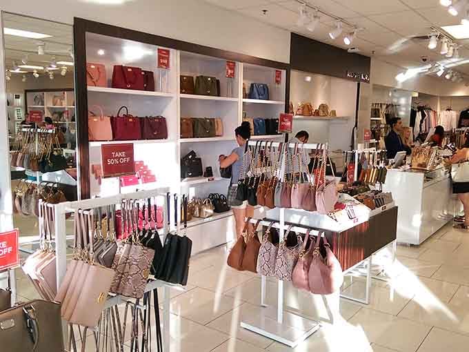 Handbags in every shade of the rainbow, organized like a candy store for people who collect purses instead of sweets.