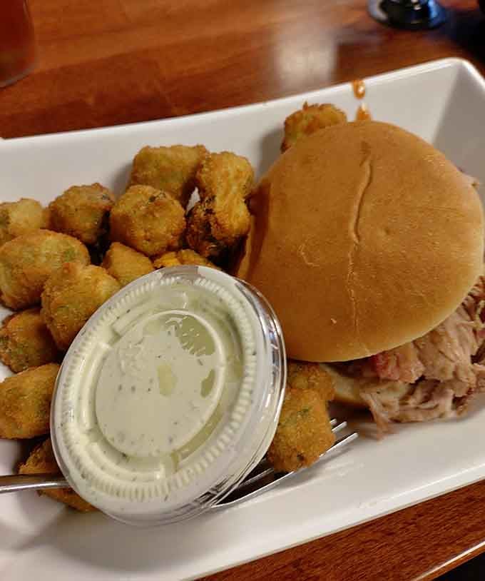This pulled pork sandwich comes with fried okra because apparently someone here believes in true happiness.