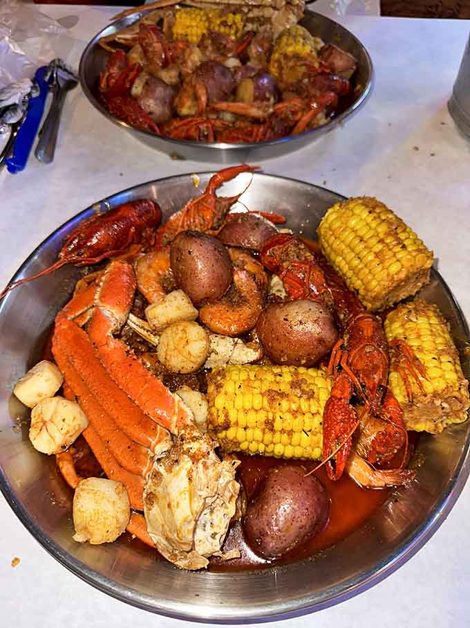 Two trays of pure seafood heaven, loaded with crab legs, crawfish, shrimp, corn, and potatoes swimming in Cajun glory.