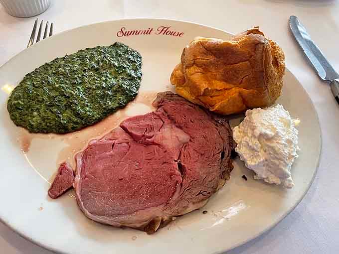 Prime rib with creamed spinach and a Yorkshire pudding that looks like it survived a delicious explosion.