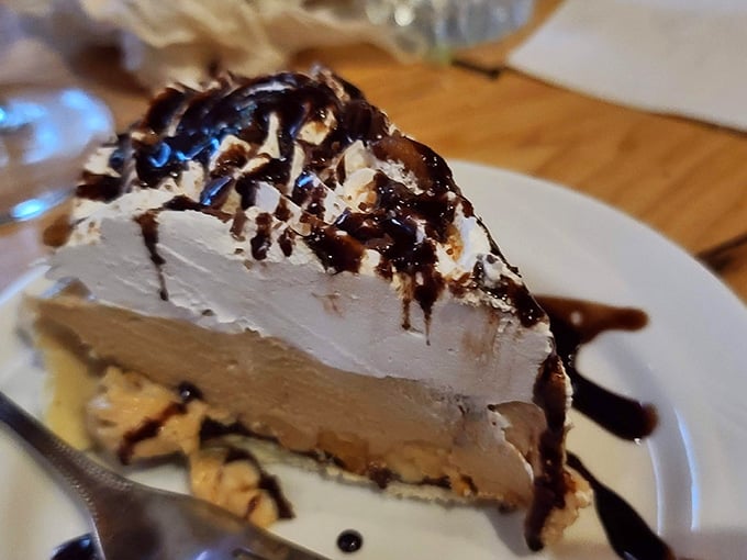This towering slice of peanut butter pie proves that sometimes dessert should require architectural engineering to stay upright.