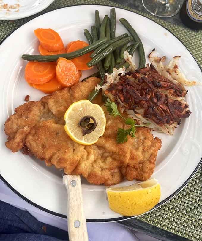 Golden, crispy schnitzel paired with perfectly cooked vegetables proves some classics never need updating, just appreciating.