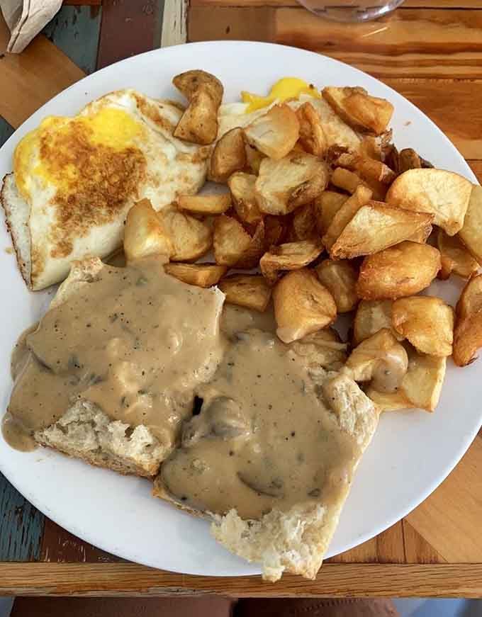 Biscuits drowning in gravy alongside perfectly cooked eggs and golden potatoes: this is how mornings should always start.