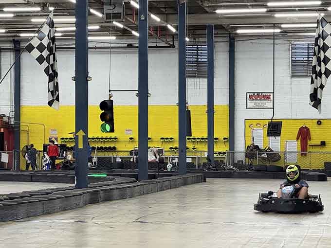 Yellow walls frame the track where drivers test their skills, helmets on and competitive spirits fully engaged.