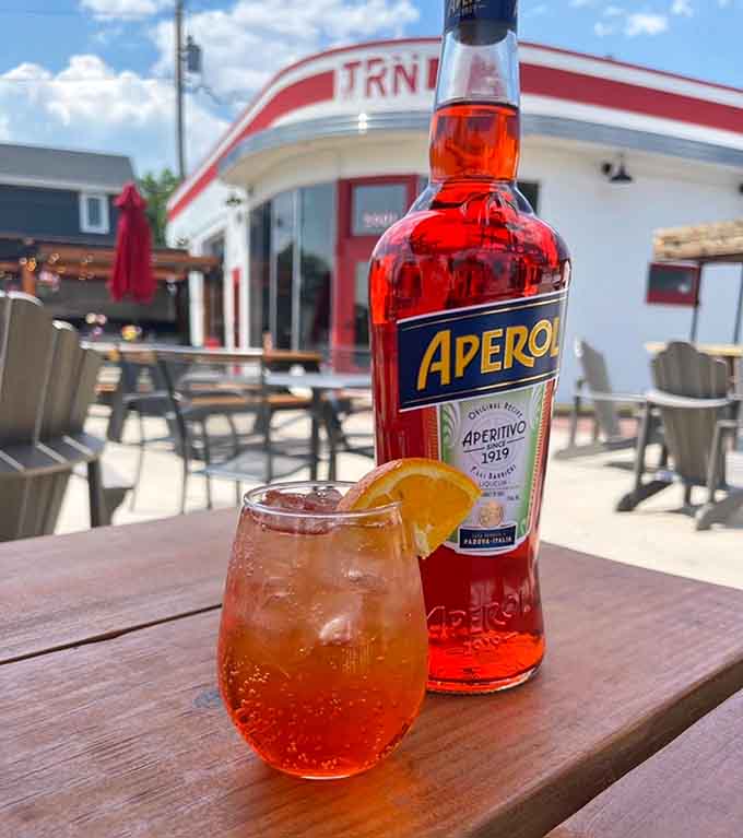 An Aperol Spritz on the patio with that classic gas station backdrop – now that's what we call adaptive reuse.