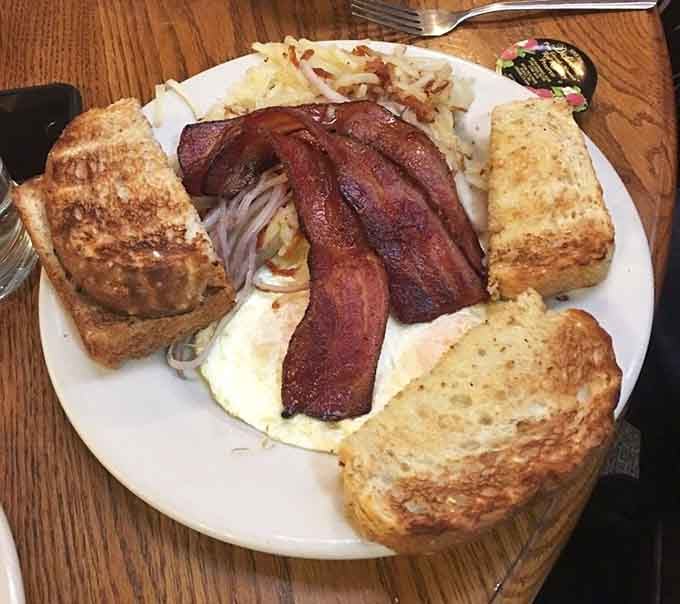 Behold the breakfast plate that launched a thousand return visits, loaded with eggs, bacon, and golden toast.