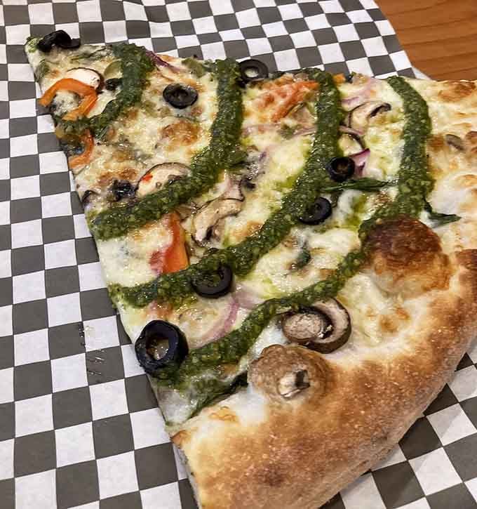 Garden pesto drizzled artfully across this pie makes vegetables look downright glamorous on a pizza canvas.