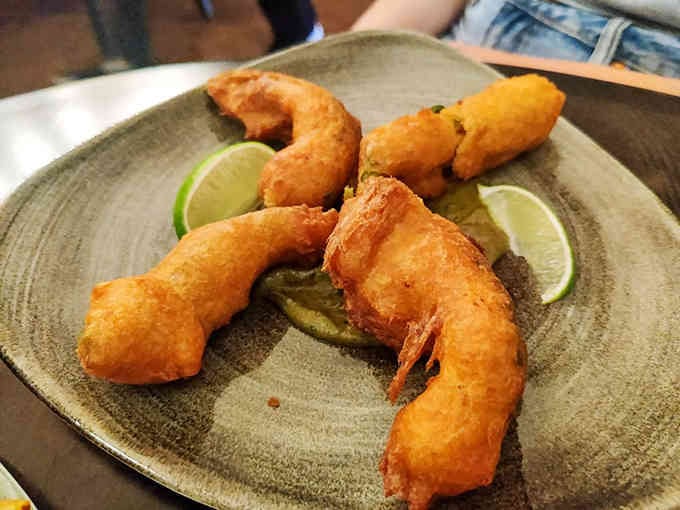 Golden-fried perfection with lime wedges waiting patiently proves that sometimes simple preparations yield extraordinary results worth savoring.