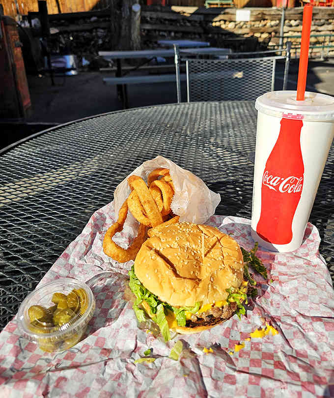 A perfectly charred burger with golden onion rings, proving that simple done right beats complicated done wrong every time.