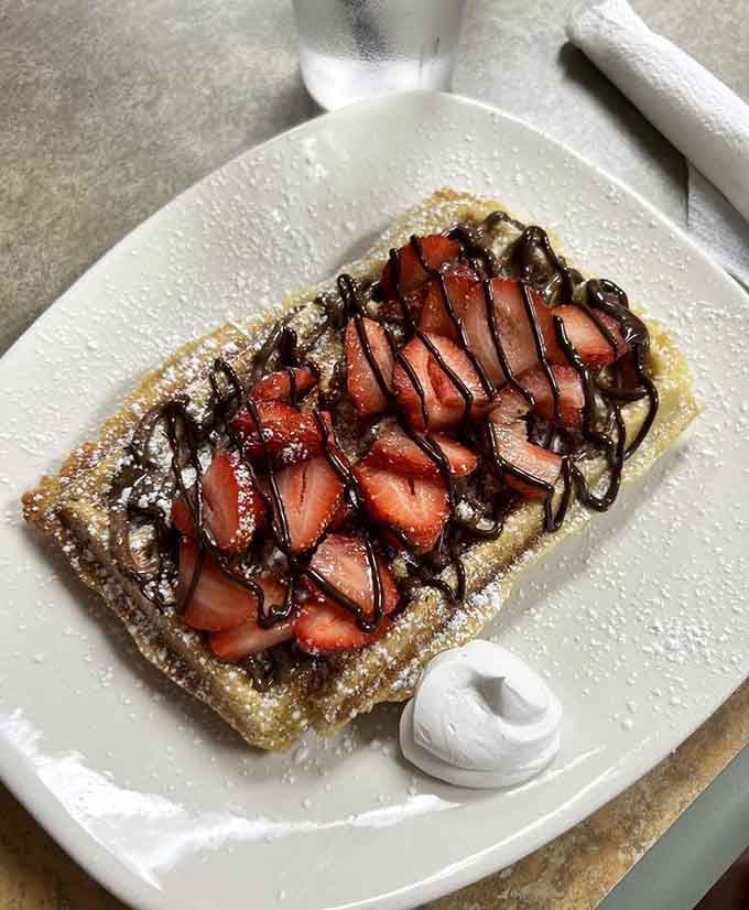 Fresh strawberries meet chocolate drizzle on golden perfection, proving dessert for breakfast is a legitimate life choice.