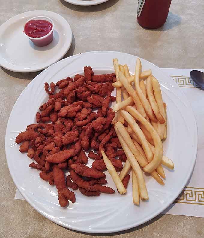Golden fried clam strips piled high next to crispy fries prove that sometimes the simplest pleasures are the most satisfying ones.