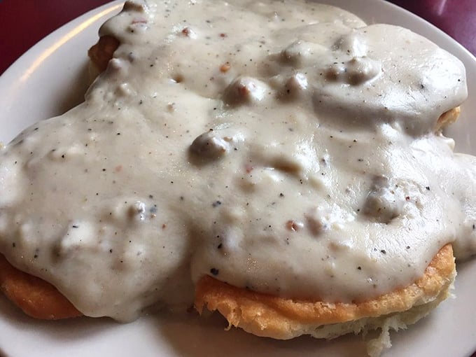 Behold: biscuits so fluffy they practically levitate, drowning in gravy that'll make you forget your own name.