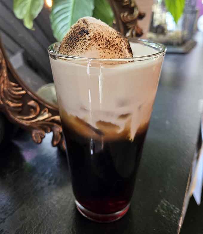 Toasted marshmallow crowns this dark brew like a sweet, torched cloud floating on liquid midnight.