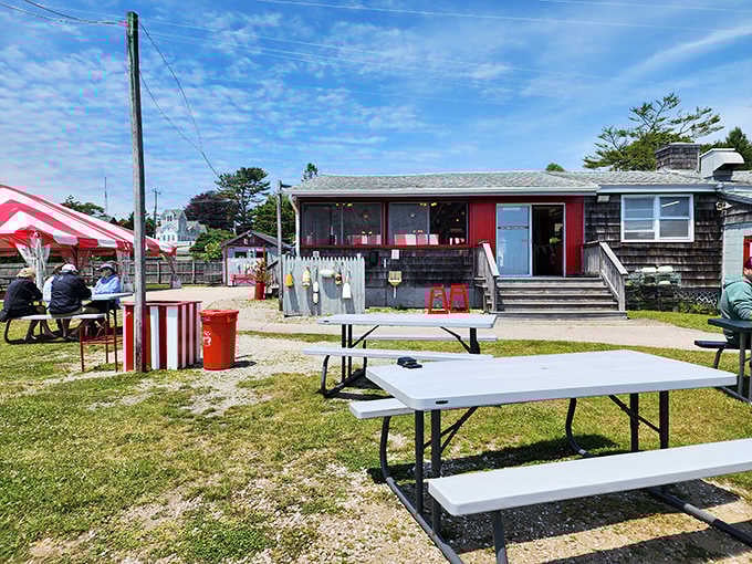 Picnic tables and striped awnings signal serious seafood ahead, no fancy clothes required for this coastal feast.