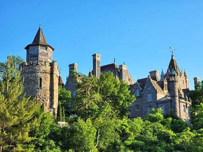Peeking through summer greenery, those varied rooflines and chimneys tell stories of architectural ambition and artistic vision.