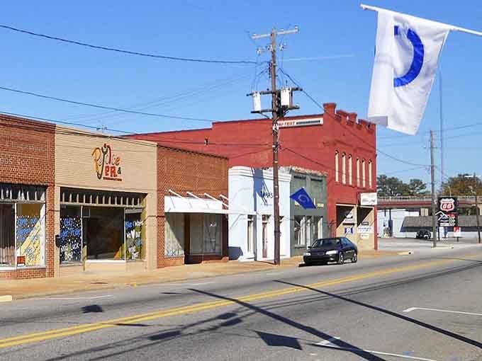 Local flags flutter above storefronts that serve neighbors, not tourists rushing through on their way elsewhere.