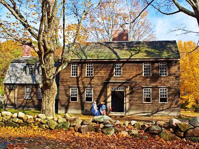 Golden autumn leaves frame this brown colonial beauty, its stone wall and shuttered windows whispering tales of revolutionary times.