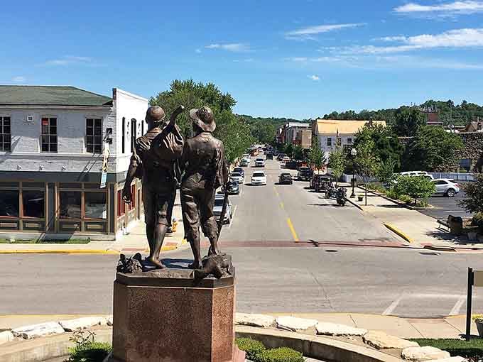 Two bronze figures gaze down Main Street, forever frozen in a moment that captures small-town American friendship perfectly.