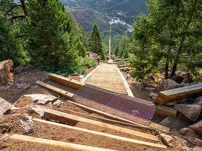 The wooden steps stretch upward through mountain terrain, each plank marked with numbers counting your journey toward the clouds.