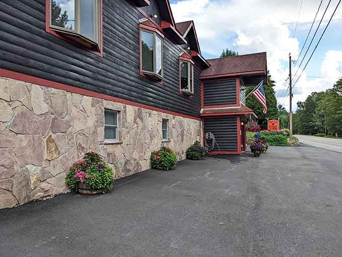 The stone foundation and vibrant flower baskets create that perfect Adirondack lodge vibe you've been craving all week long.