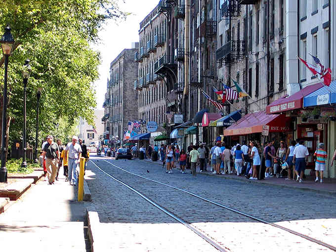 Cobblestone streets and iron balconies create Savannah's famous River Street, where tourists and locals mingle under the Southern sun.