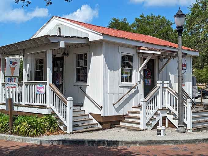 This charming white cottage with its red roof looks like something Norman Rockwell would paint on Sunday.