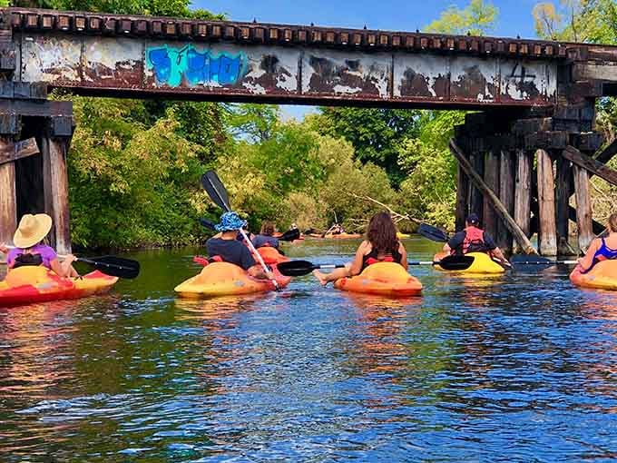 Paddling under rusty bridges with colorful kayaks creates the kind of Instagram moment your grandkids will actually appreciate.