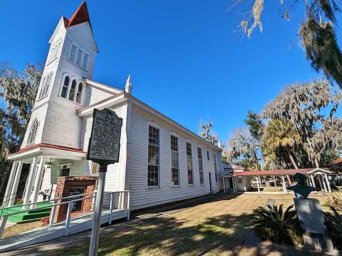 That white church steeple reaches skyward while moss-covered oaks frame this peaceful scene like a postcard from heaven itself.