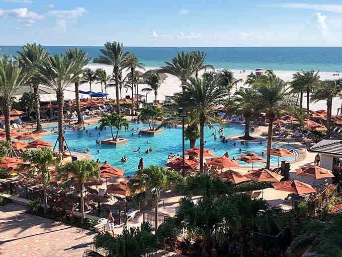 Palm trees frame a resort pool that makes you wonder why anyone would choose a landlocked vacation ever again.