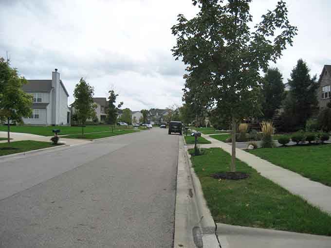 Tree-lined streets and manicured lawns create neighborhoods where kids still ride bikes and parents actually sit on their front porches.