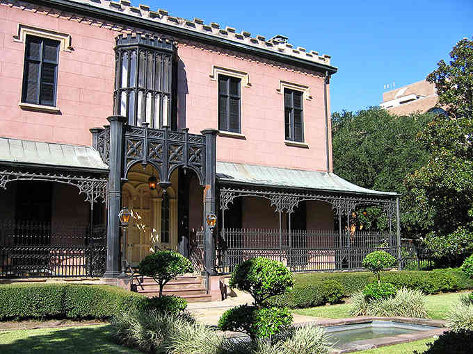 That pink mansion with ornate ironwork and manicured gardens shows why Savannah's historic homes make jaws drop and cameras click.