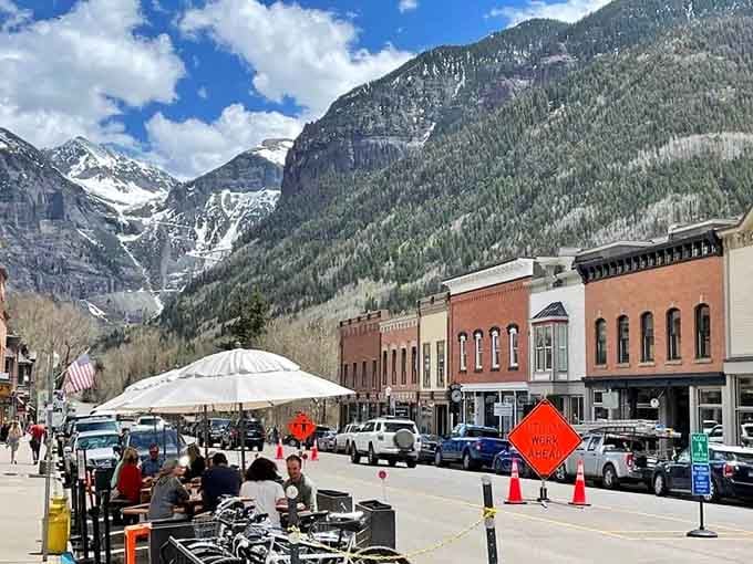 Snow-dusted peaks tower over historic streets where outdoor dining happens with million-dollar views as your backdrop.