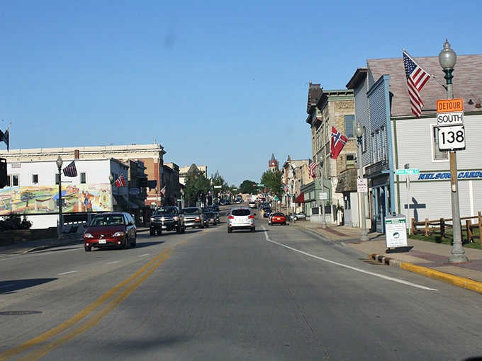 Flags wave proudly above storefronts where locals still know your name and remember how you take your coffee.