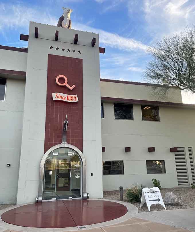 The vintage tower entrance with its branding iron logo promises authentic Western dining inside these walls.