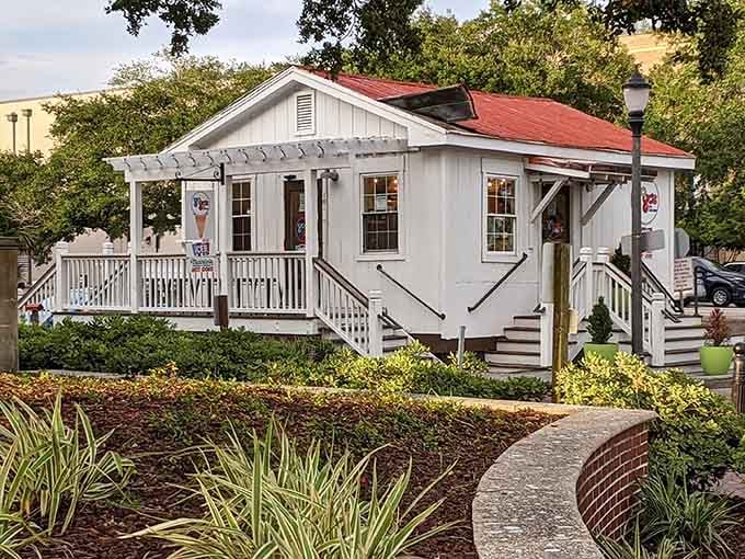 Brick pathways and manicured gardens frame this adorable structure like a postcard from simpler times.