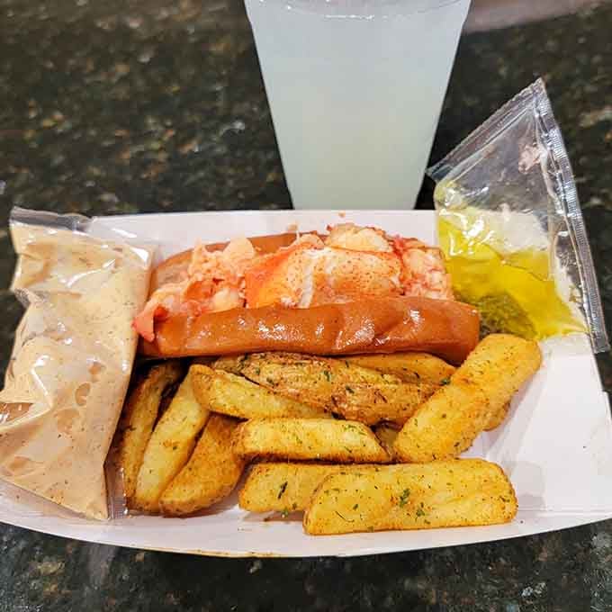 The Connecticut-style lobster roll glistens with butter, proving that sometimes warm beats cold in the eternal debate.