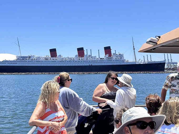 Real passengers enjoying real transit, with the Queen Mary photobombing in the background like a celebrity at Disneyland.