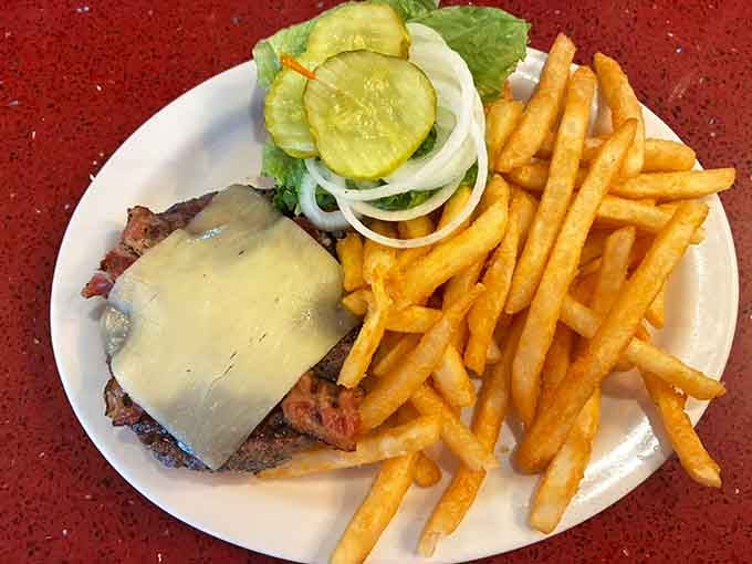 That burger's wearing cheese like a crown, and those fries are golden enough to make King Midas jealous.