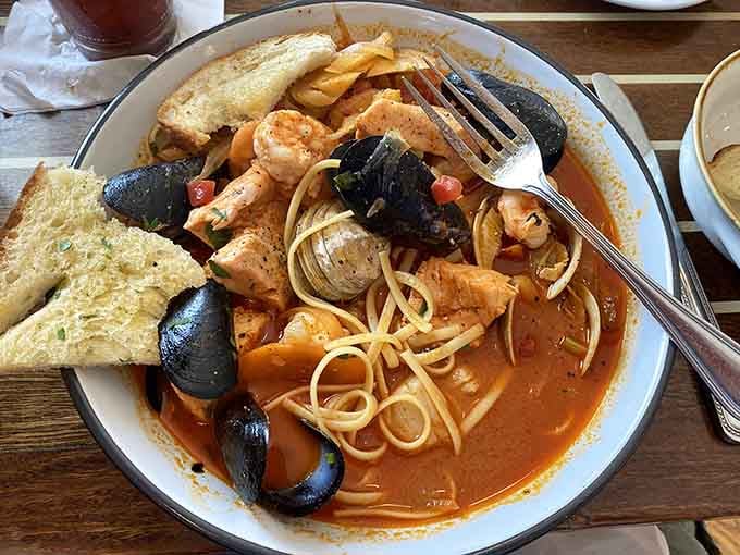 That steaming bowl of seafood pasta with mussels and shrimp is pure comfort in edible form.