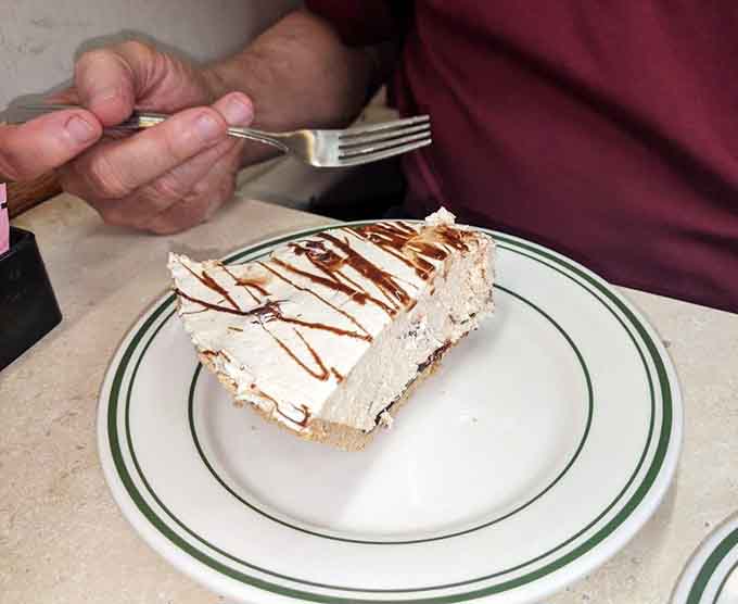 Chocolate peanut butter pie topped with enough whipped cream to make your cardiologist schedule an intervention, worth every bite.