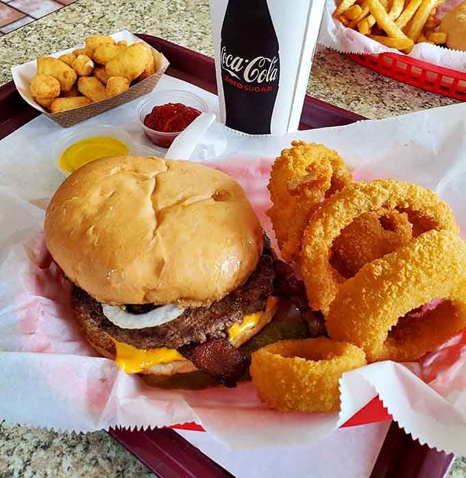 Golden onion rings circling a burger like Saturn's rings orbit a planet made entirely of deliciousness.