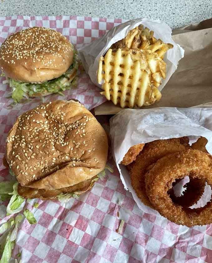 Fish burgers flanked by waffle fries and onion rings: the holy trinity of drive-in perfection in one glorious spread.
