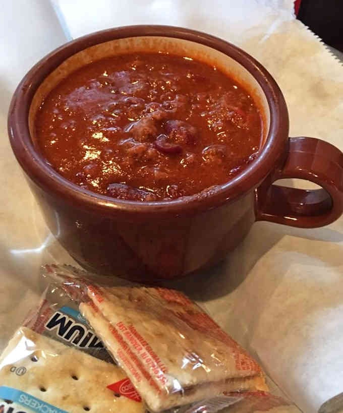 This chili arrives in a proper mug because sometimes comfort food needs to feel like a warm hug.