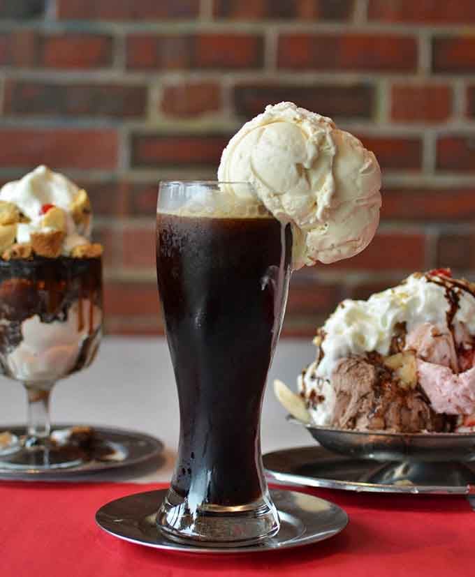A root beer float with ice cream perched on top like it's surveying its fizzy kingdom below.