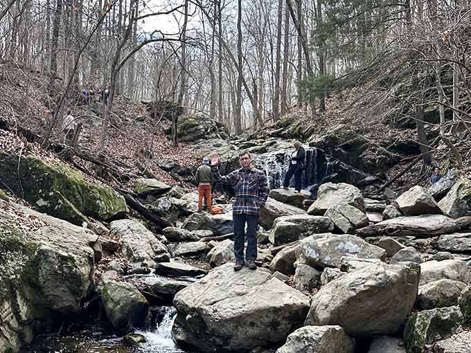 Rocky terrain and winter's bare trees frame the falls, showing how the landscape transforms when temperatures drop significantly.