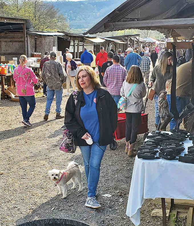 Crowds browsing under open skies with mountains watching, where shopping becomes a genuine community gathering every single weekend.