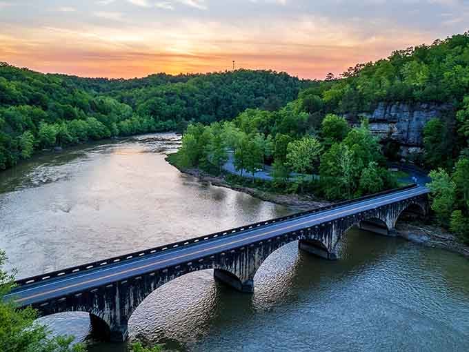 This graceful bridge at sunset proves that sometimes the journey to the waterfall is just as photogenic as the destination itself.