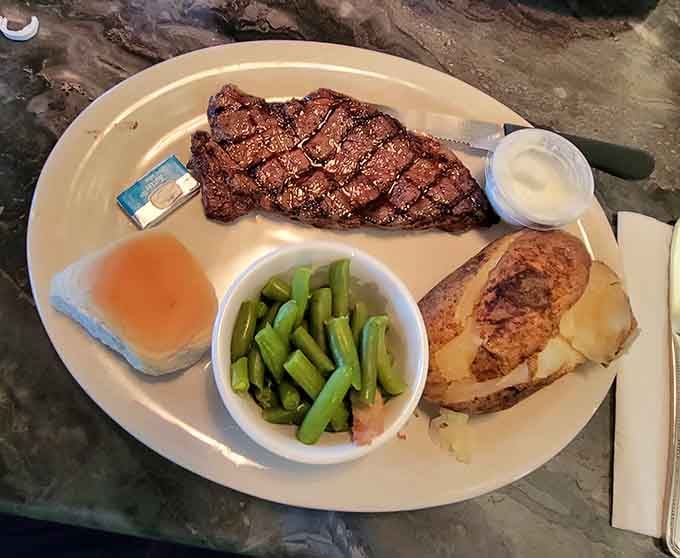 That perfectly grilled steak with baked potato looks like it means serious business in the best way.