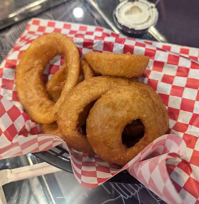 Golden onion rings so perfect they look like they were cast in a Hollywood movie about comfort food dreams.