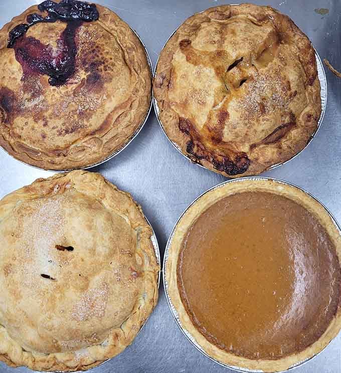 A quartet of beauties: berry, apple, and what appears to be pumpkin, each crust telling its own story.